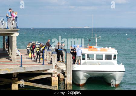 Divers disembarking from a Catamaran onto Swanage Pier Dorset England ...
