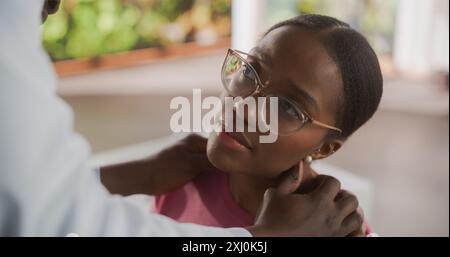 Black Physician Inspect Neck Muscles For Any Damages of a Female ...