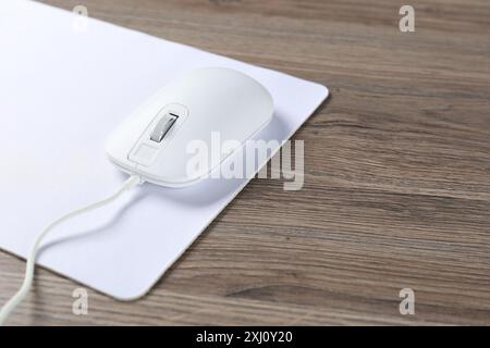 Computer mouse with mousepad on wooden desk, top view. Space for text ...