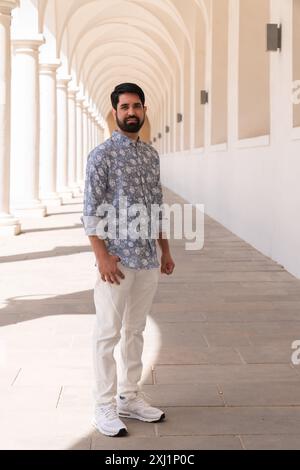 A modern, stylish Pakistani man with a dark beard and light clothes ...