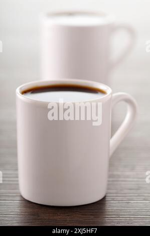 two cups full of coffee on wooden background Stock Photo - Alamy