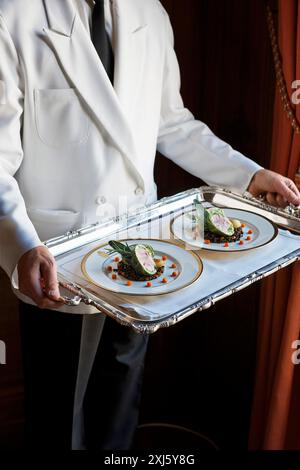 Waiter carrying two plates with meat dish on some festive event, party ...