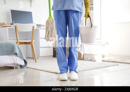 Janitor with mop and bucket in dorm room Stock Photo - Alamy