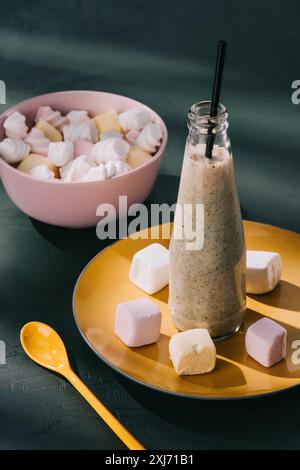 closeup shot of milkshake in bottle with drinking straw, bowl with ...