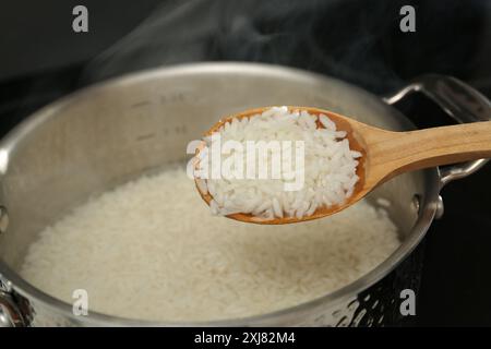 Taking boiled rice from pot with spoon, closeup Stock Photo - Alamy