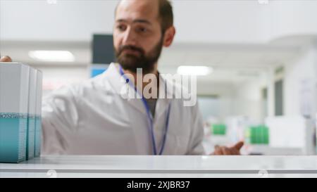 Pharmacy worker emptying shelves for stock reorganization, putting all ...