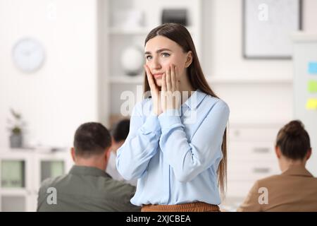 Woman feeling embarrassed during business meeting in office Stock Photo ...