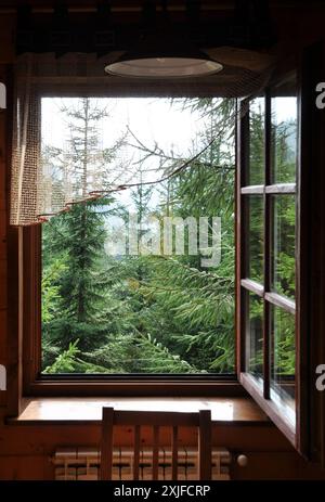 Window in a mountain hut overlooking a mountain range, decorated for ...