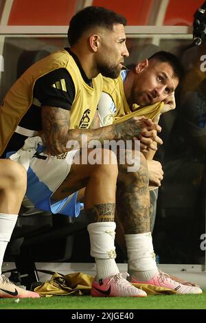 Argentine forward Lionel Messi (C) reacts while sitting on the bench ...