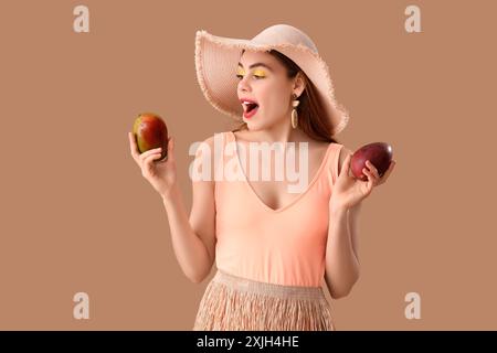 Shocked young woman with sweet mango fruits on beige background Stock ...