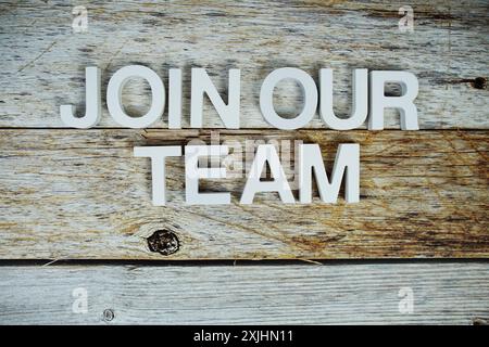 Join our team alphabet letters with wooden block top view on wooden ...
