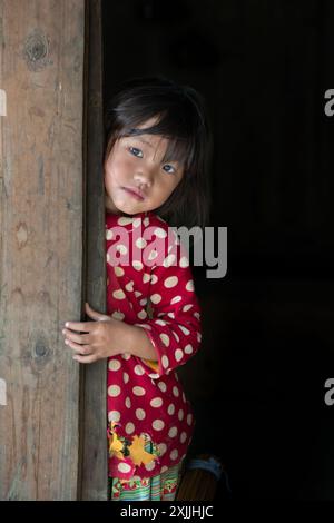 Young Hmong girl looking from behind a door, Lao Cai Province, Vietnam ...