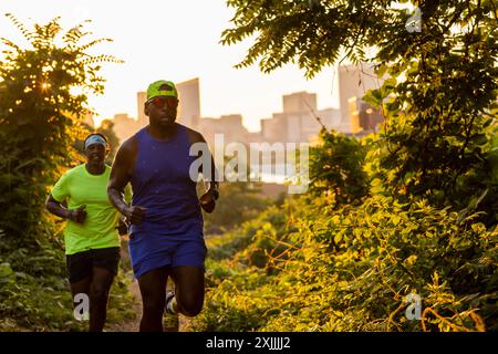 Two friends trail running with a skyline in the background Stock Photo ...