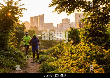 Two friends trail running with a skyline in the background Stock Photo ...