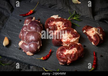 Raw beef kidney meat on stone board with thyme and peppers, cattle ...