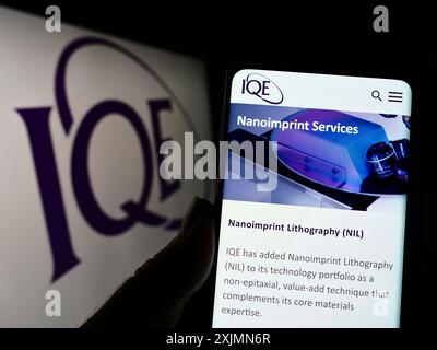 Cellphone with logo of British semiconductor company IQE plc on screen ...