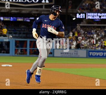 Boston Red Sox' Jarren Duran, right, is held back by third base coach ...