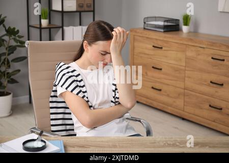 Embarrassed woman at wooden table in office Stock Photo - Alamy