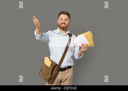 Postman with brown bag delivering letters on grey background Stock ...