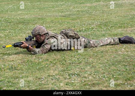 COLCHESTER ENGLAND June 29 2024: Assault Rifleman lying prone pointing ...