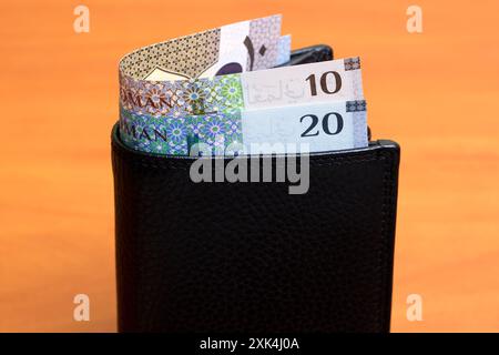 Omani money - rial in the black wallet Stock Photo - Alamy
