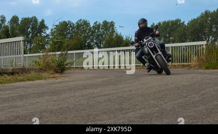 motorbike tilted exiting a corner driving past a bridge banking right ...
