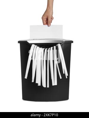 A woman is cutting a sheet of white paper using metallic scissors ...