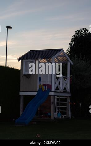 an empty playground with a red slide at night with fog and creepy ...