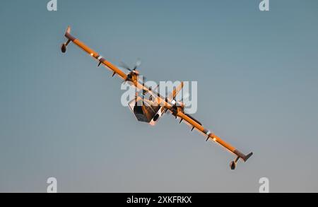 A firefighting aircraft is in action above a clear sky, engaged in ...