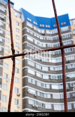 Skyscraper behind a barbed wire fence in a residential area, showcasing ...