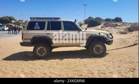A Toyota Landcruiser parked on the sand by the beach in Essaouira ...
