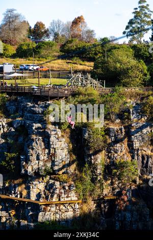 A girl ziplines across the Graskop Gorge. View of Graskop Gorge along ...