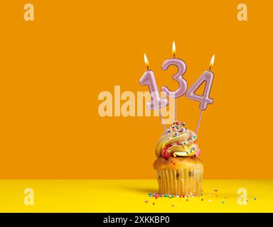 Lighted birthday candle number 134 - Birthday card on pink background ...