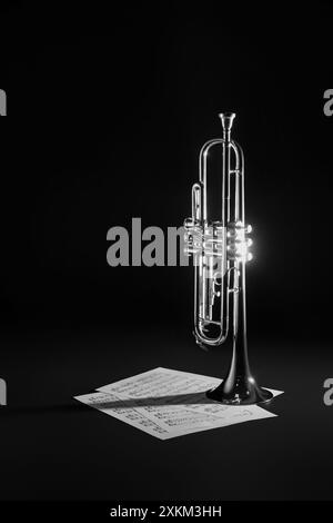 Shiny trumpet and music sheets on dark background. Wind musical ...