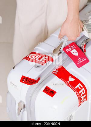 Luggage tag (Fragile, Handle with care) attached to suitcase Stock ...