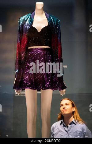 A gallery assistant looks at the outfit worn by Taylor Swift on the ...
