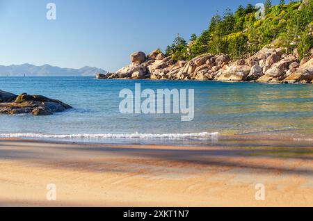 Picturesque golden sandy Alma Beach with granite boulders and turquoise ...