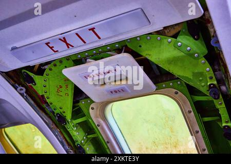 Emergency exit sign in aircraft cabin ceiling. Passenger jet airliner ...