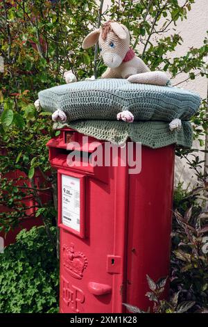 Knitted or crocheted post box topper depicting penguin characters, an ...