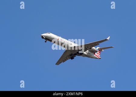 An American Eagle Airlines flight in front of a rising full moon in ...