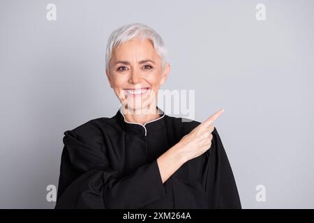 Photo of smiling old woman judge look empty space wear black robe ...
