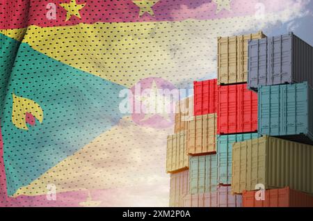 Grenada flag and big stack of shipping cargo containers in docks with ...