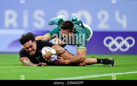 New Zealand's Leo Moses scores a try during the rugby sevens match ...