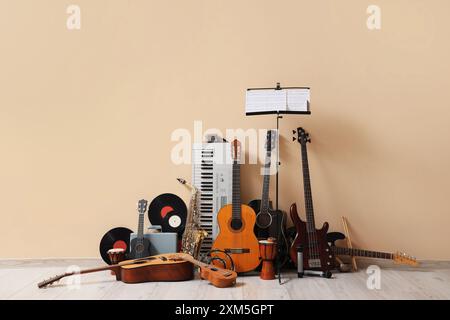 Different musical instruments near beige wall Stock Photo - Alamy