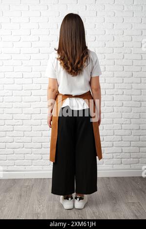 Back view Woman Wearing Apron in Front of a White Brick Wall Stock ...