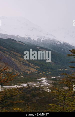A mountain range with a river running through it. The river is clear ...