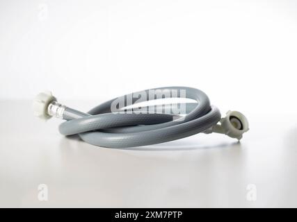 Gray twisted water hose from a washing machine on a white background ...