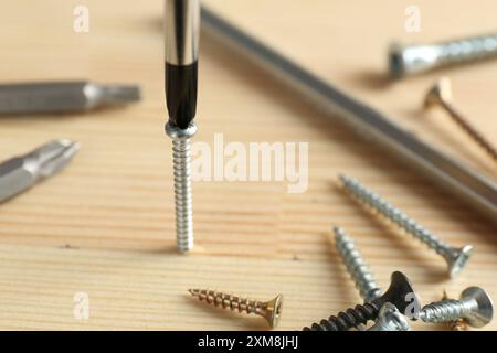 Screwing screw into wooden plank with bits, closeup Stock Photo - Alamy