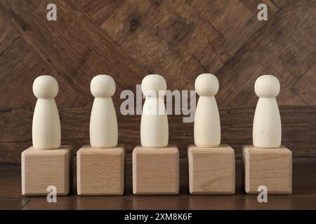Human figures on cubes, wooden one on top against violet background ...