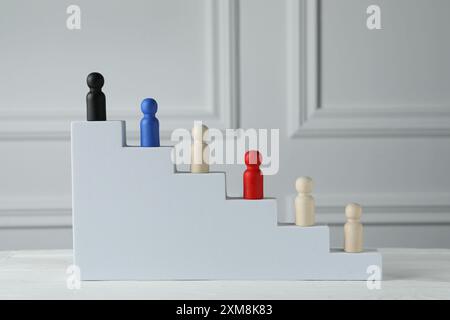 Stairs with group of different wooden human figures and road sign on ...